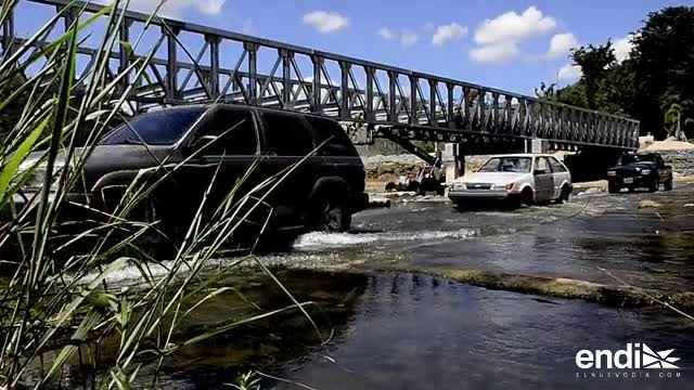Los carros cruzan sobre un río para poder entrar y salir de Morovis ...